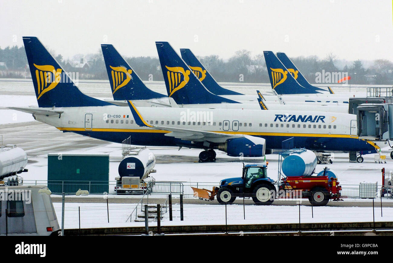 Ryanair planes wait on the snow-covered tarmac at Stansted Airport in ...