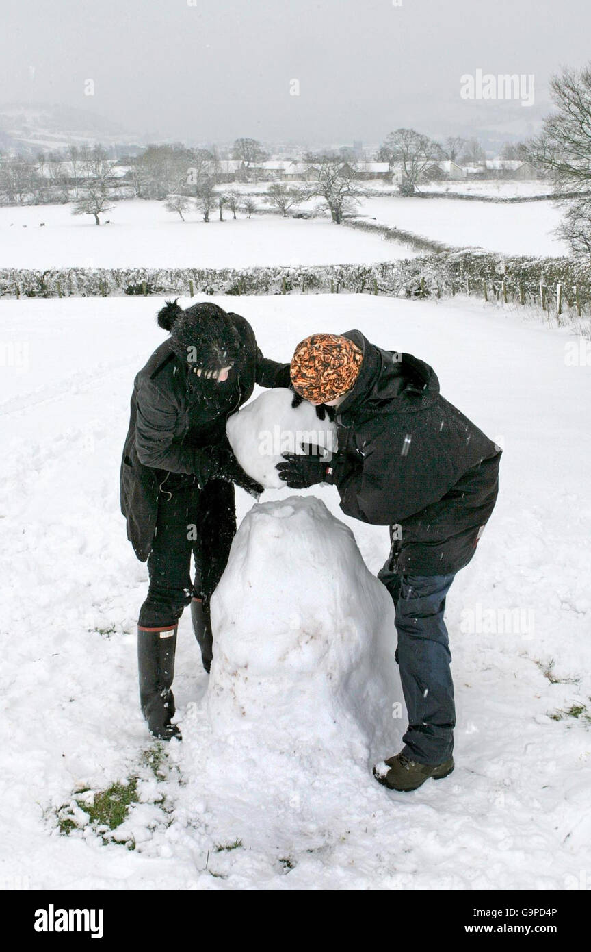 Heavy snowfall across the UK. Children make a snowman in Brecon, Wales ...