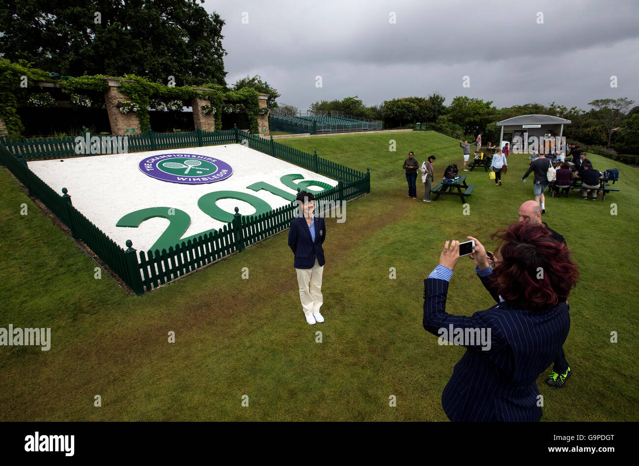 A Wimbledon line judge poses for a photo in front of a Wimbledon ...