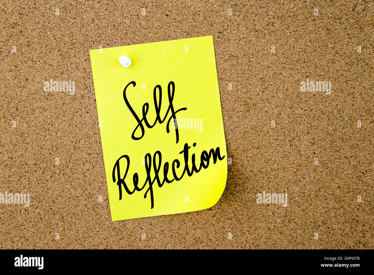 Self Reflection written on yellow paper note pinned on cork board with ...