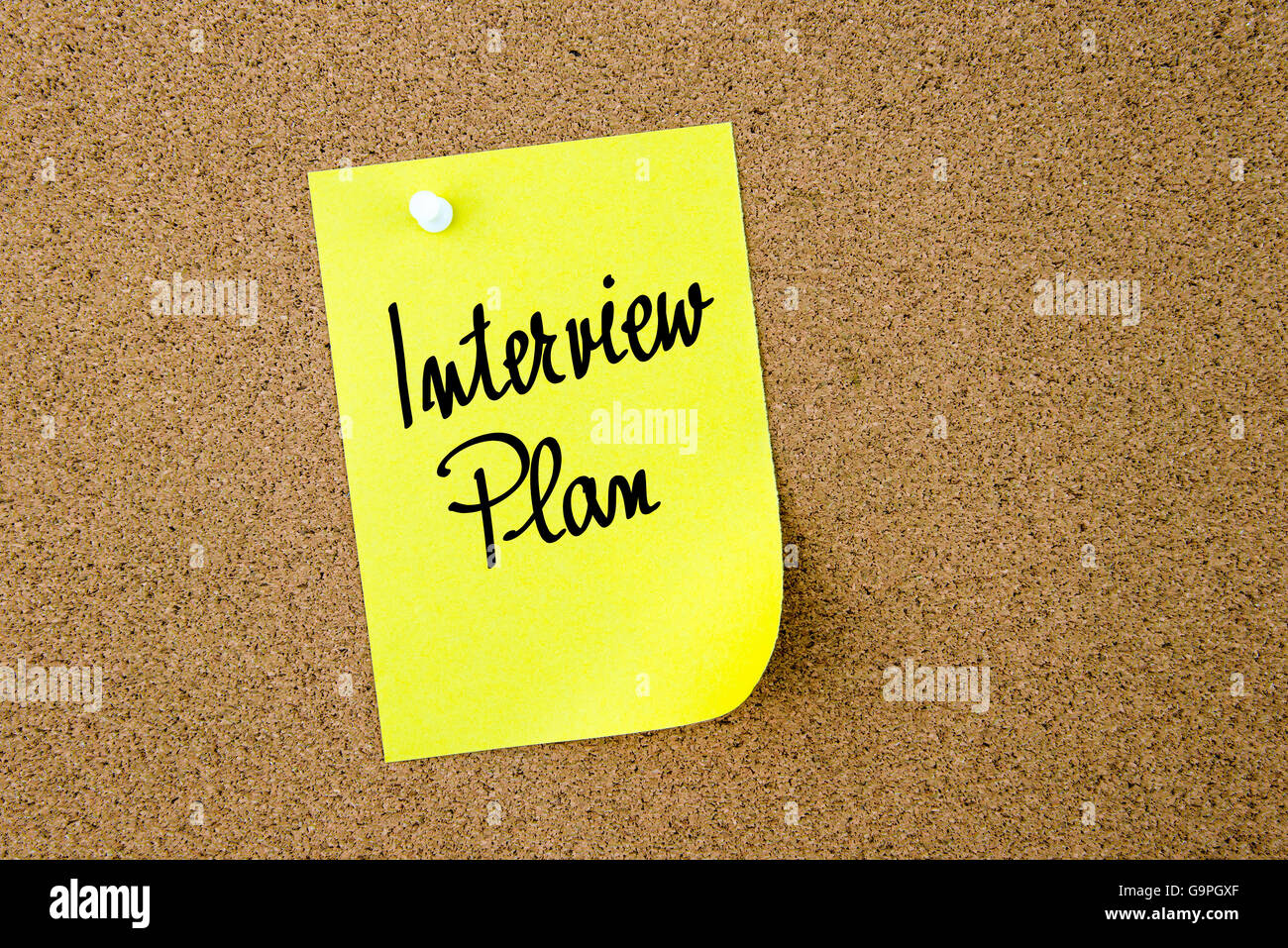 Interview Plan written on yellow paper note pinned on cork board with ...