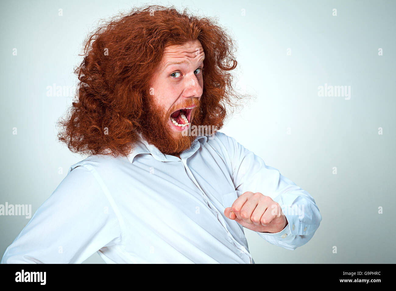The young smiling man with long red hair looking looking playfully ...