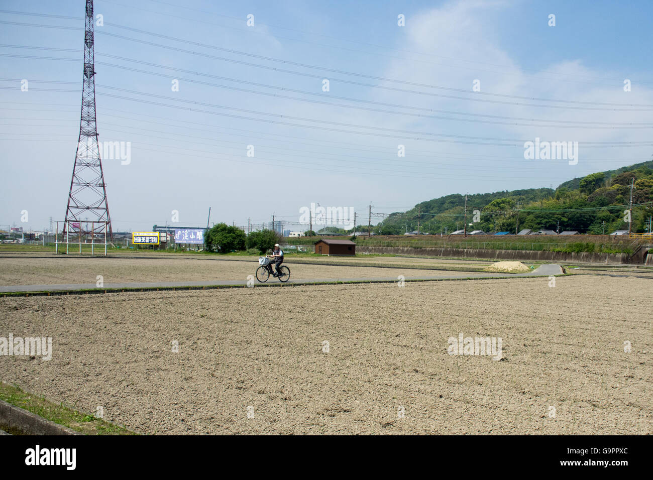 A cyclist riding on a path between two fallow fields Stock Photo - Alamy