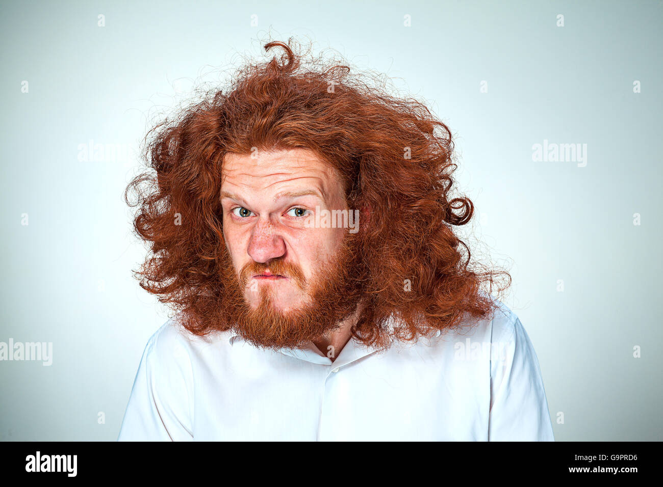 The young angry man with long red hair Stock Photo - Alamy