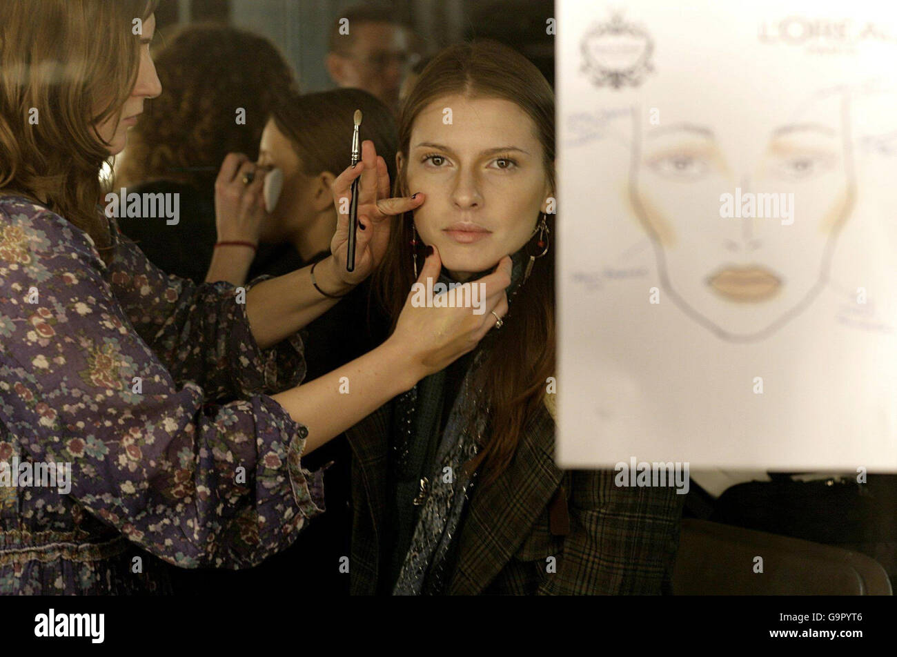 A model has her makeup applied backstage prior to the Hamish Morrow ...