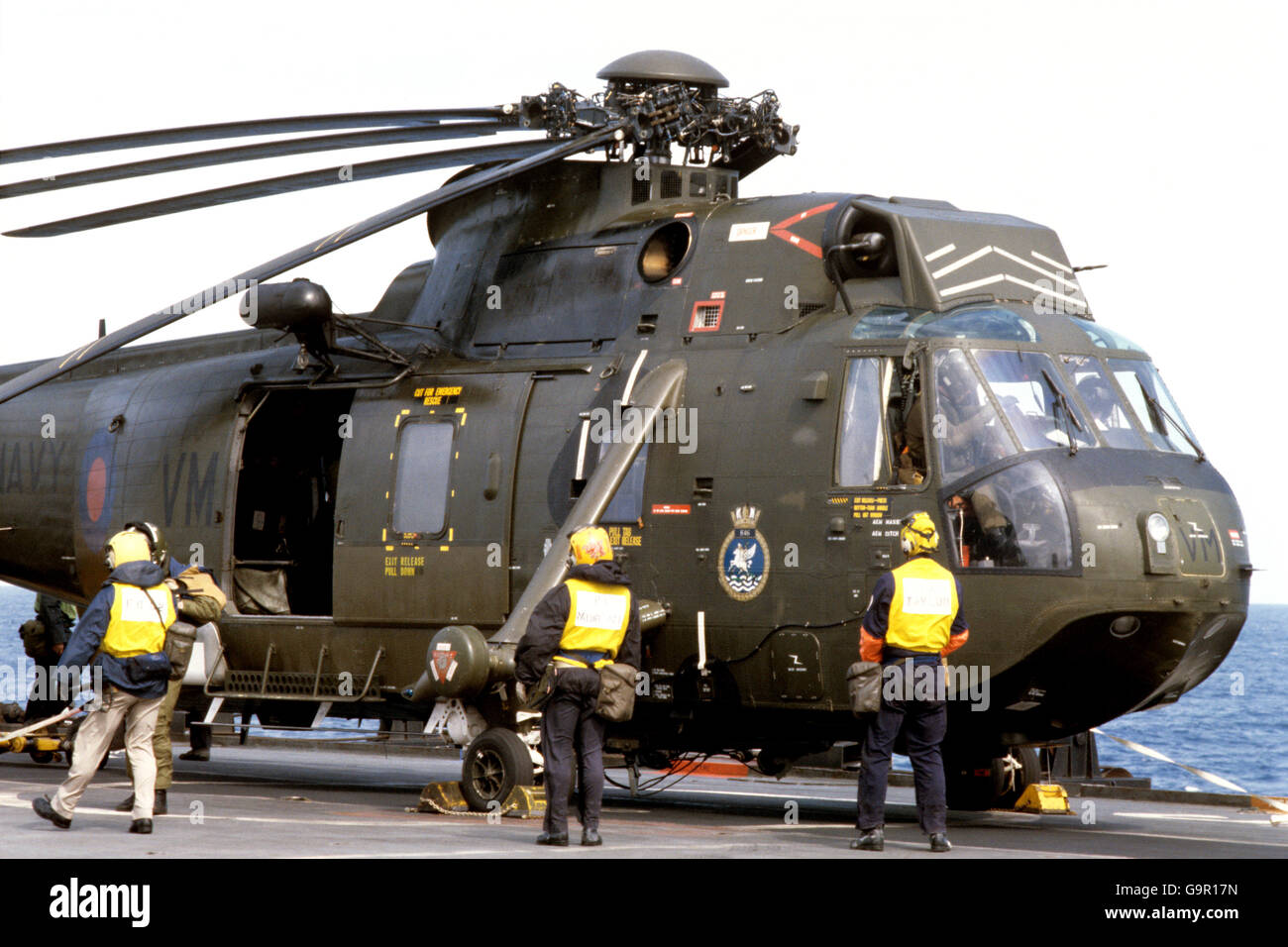Navy Personnel preparing a Sea King helicopter for take-off on the deck ...