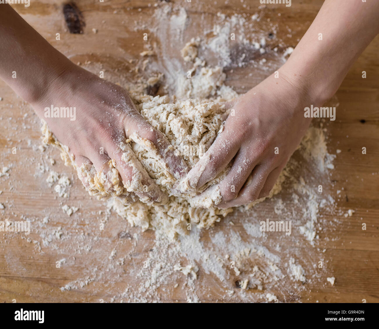 Close-up of two strong hands of a baker that are manually kneading ...
