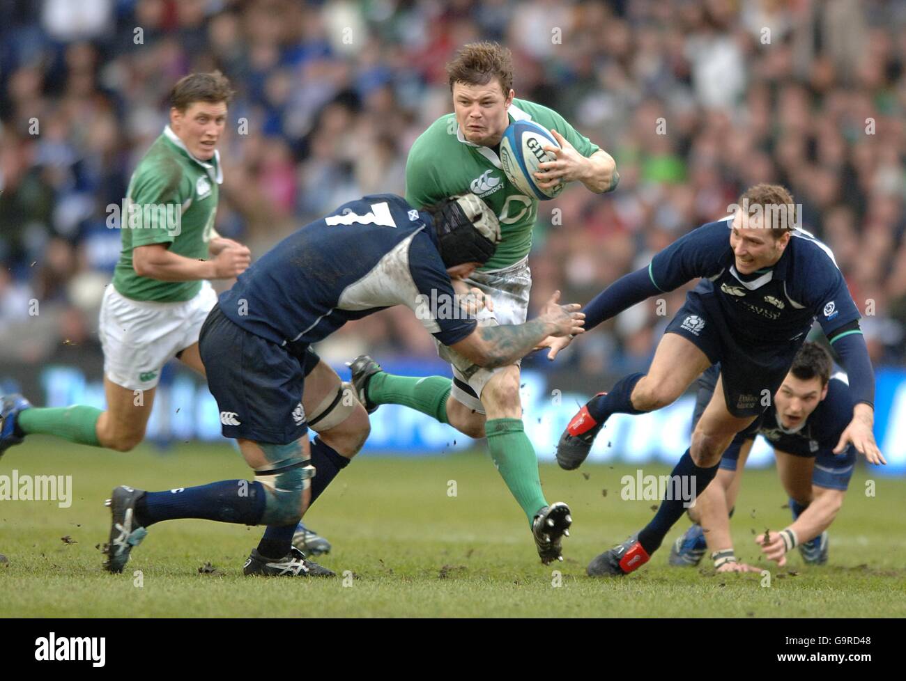 Ireland's Brian O'Driscoll (c) tries to break the challenge of Scotland ...