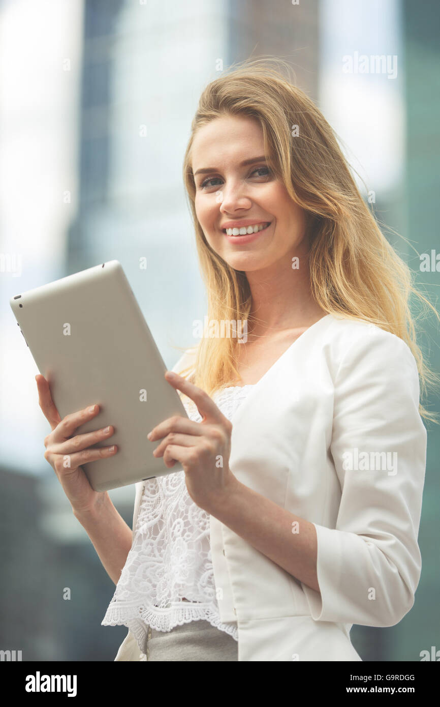 Beautiful woman using electronic tab in the street. Image toned in low ...