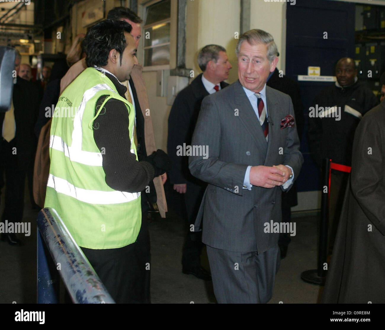 The Prince of Wales passes a ticket inspector as he arrives at Woking ...