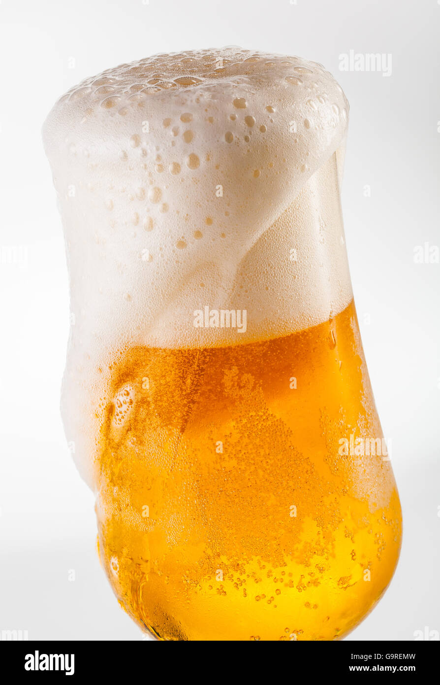 Overflowing beer in a tulip glass Stock Photo - Alamy