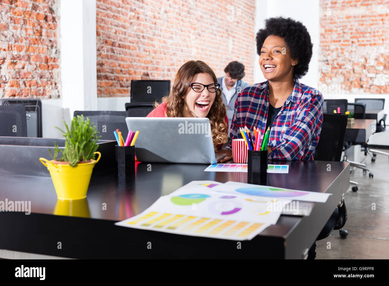 People laughing sitting office desk laptop colleagues fun joke Stock ...