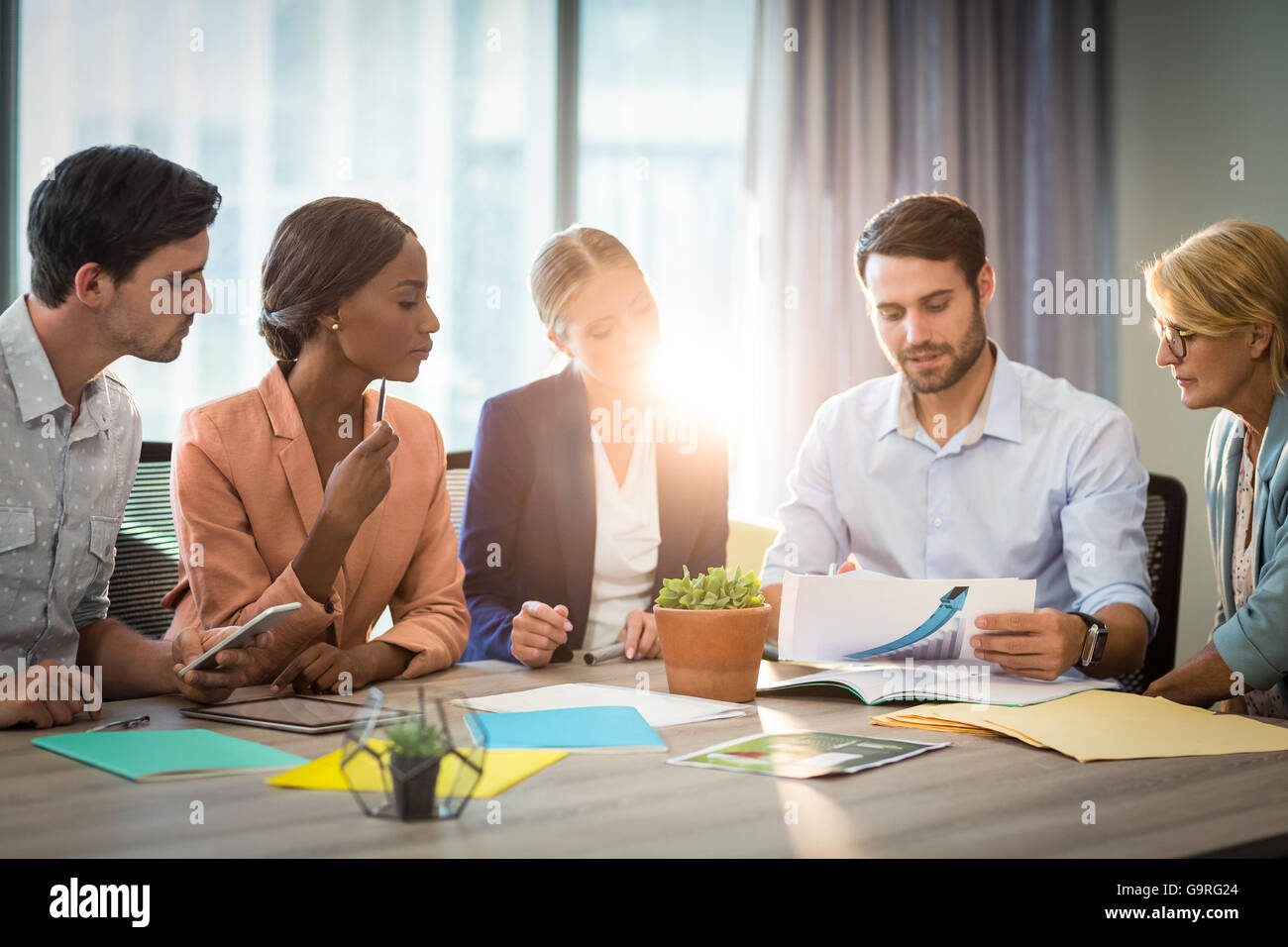 Group of business people discussing at desk Stock Photo - Alamy