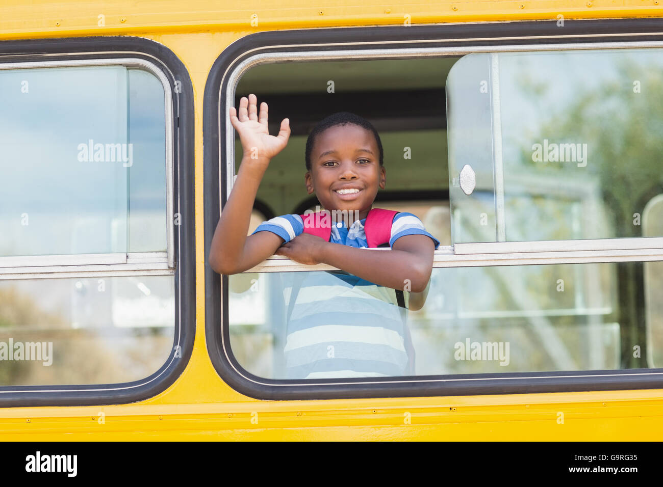 Portrait of schoolboy waving hand from bus Stock Photo - Alamy
