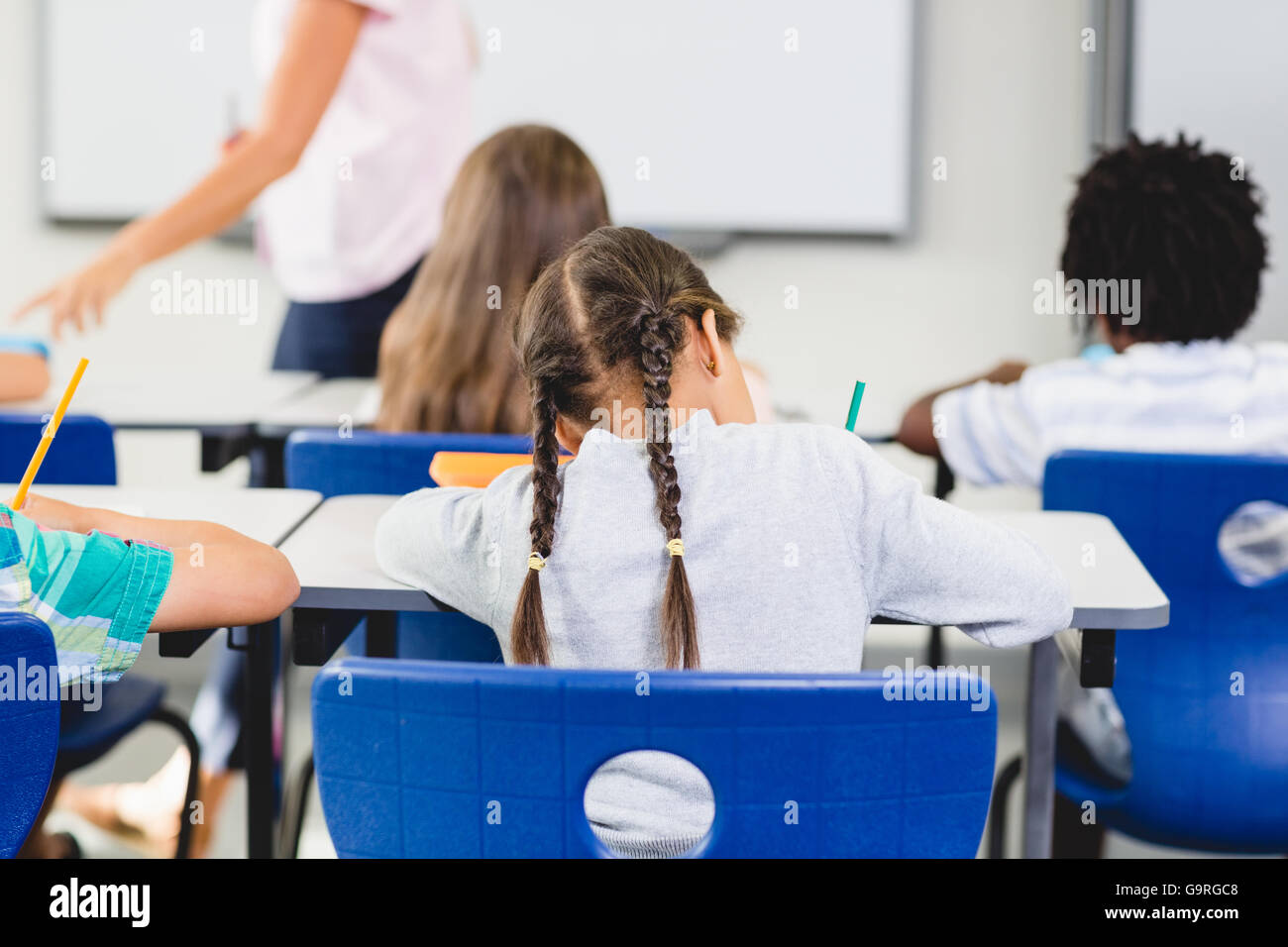 School kids doing homework in classroom Stock Photo - Alamy