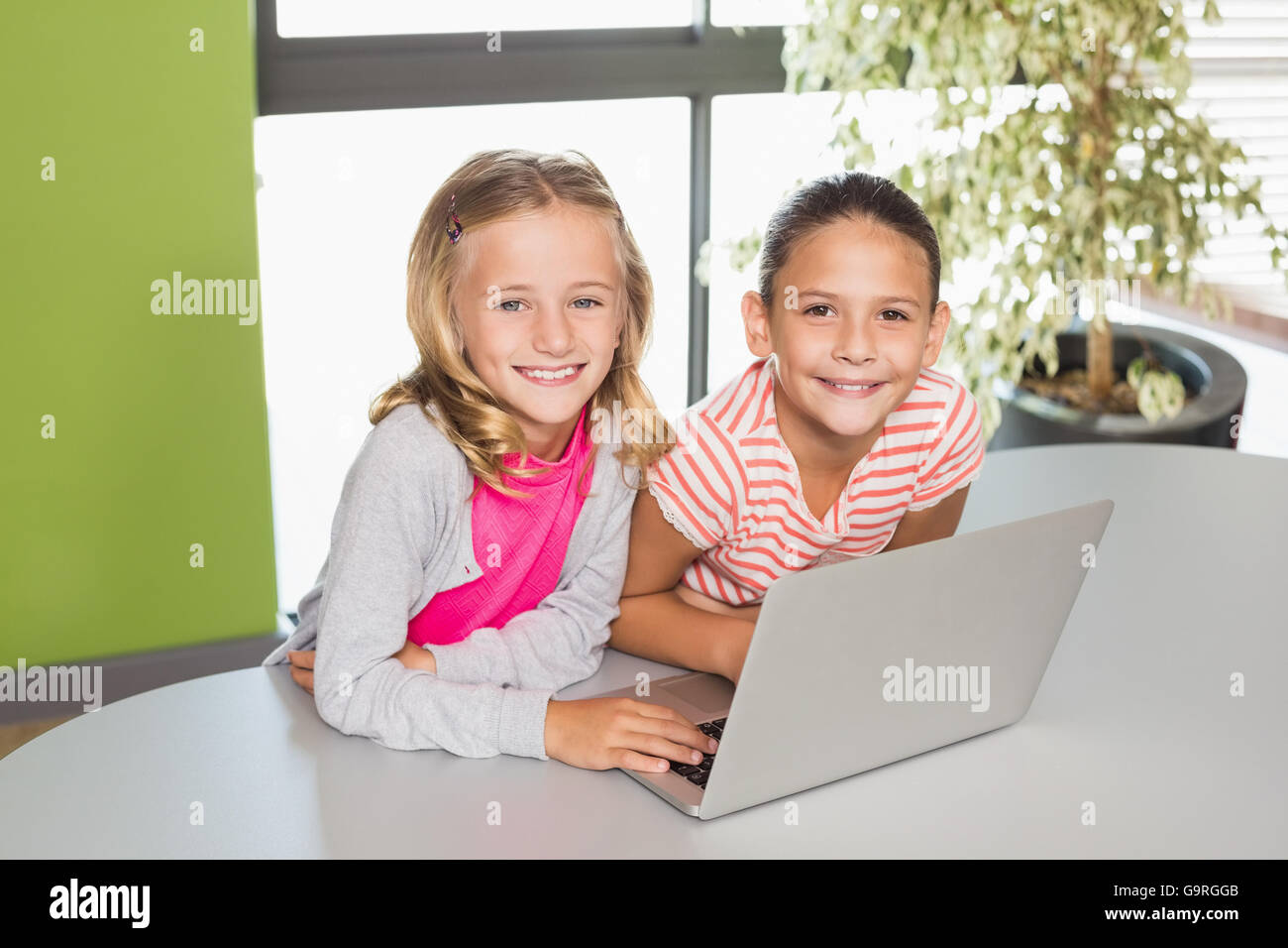 Kids using laptop in library Stock Photo - Alamy