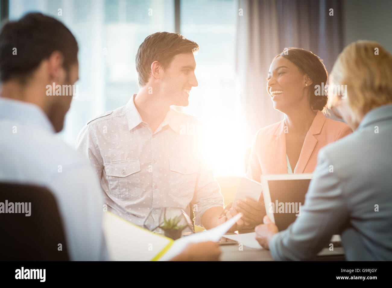 Group of business people interacting at desk Stock Photo - Alamy