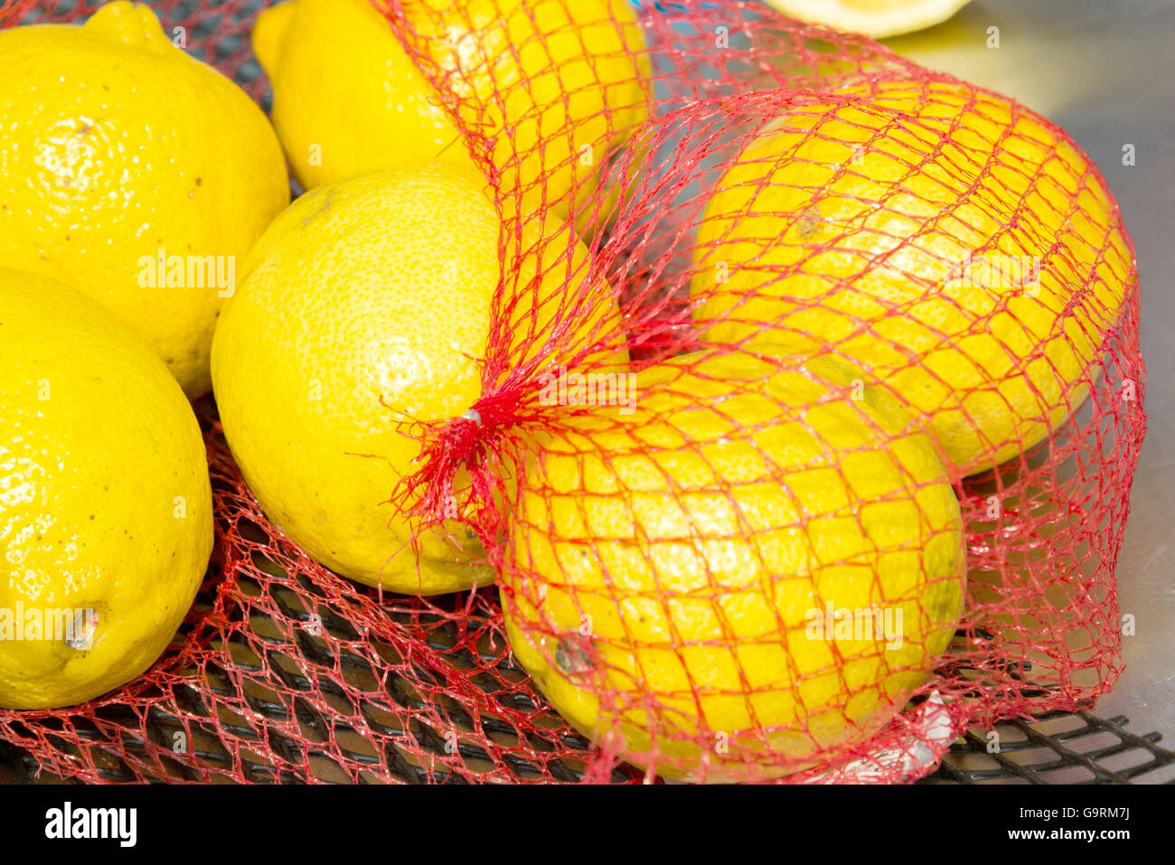the Lemons in net packaging in the grocery store Stock Photo - Alamy