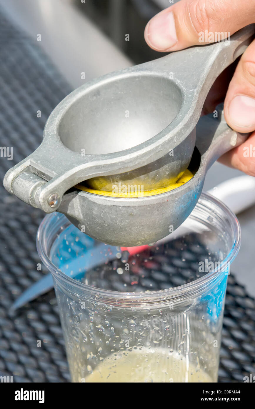 the manual metal juicer lemon in a plastic Cup Stock Photo - Alamy