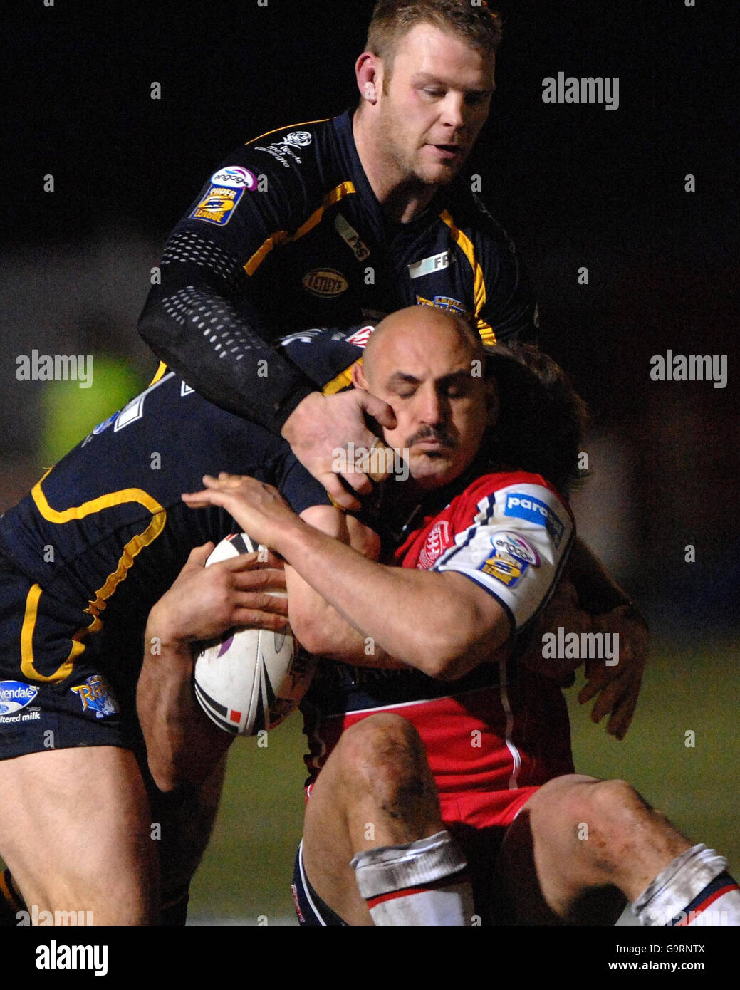 Hull KR's Mick Vella (bottom) tackled by Leeds Rhinos Gareth Ellis ...