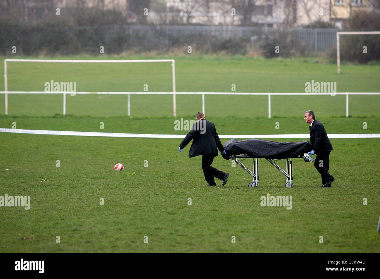 The body of a shooting victim is carried across the football pitch at ...
