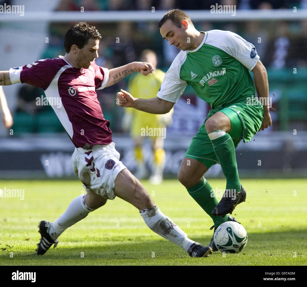 Hibernian's David Murphy (right) avoids the tackle from Heart of ...