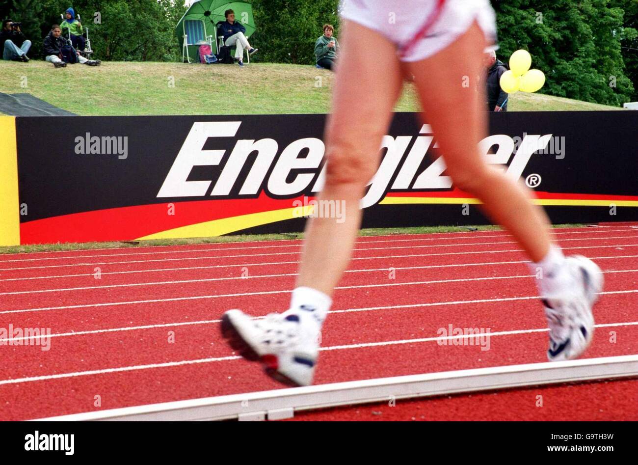 A competitor in the women's 5000m walk final passes an Energizer board ...