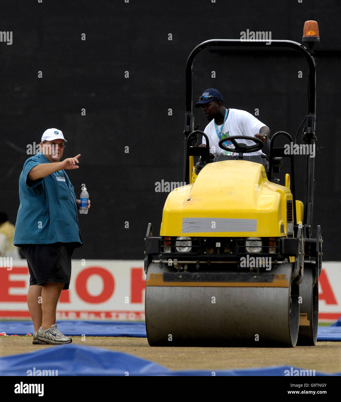 ICC groundsman from Britain, Andy Atkinson (left), instructs his staff ...