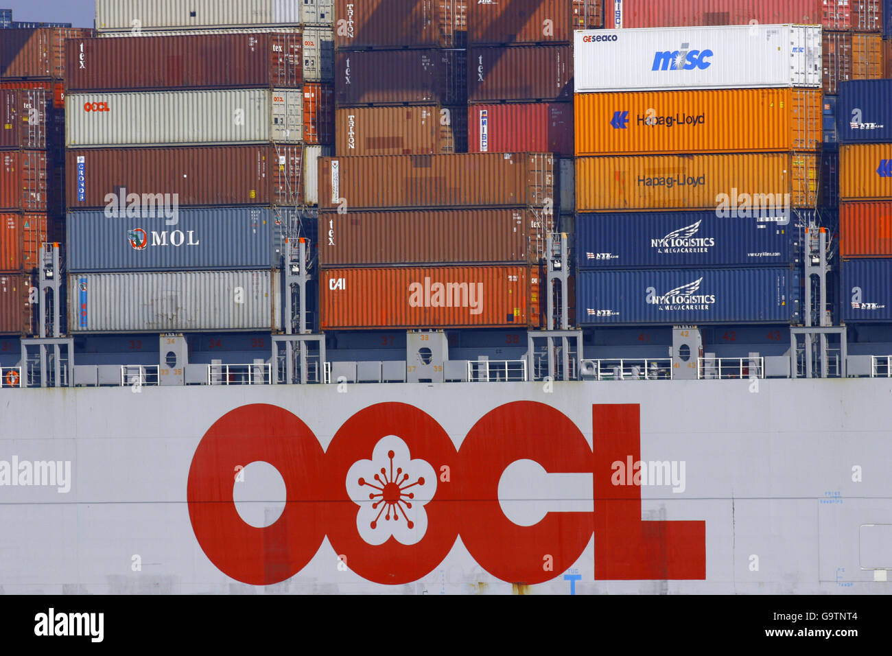 A huge container ship, the OOCL Atlanta from Hong Kong unloads cargo at ...