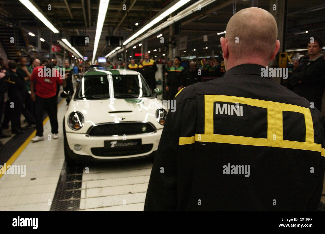 Workers watch as the one millionth Mini rolls off the production line ...