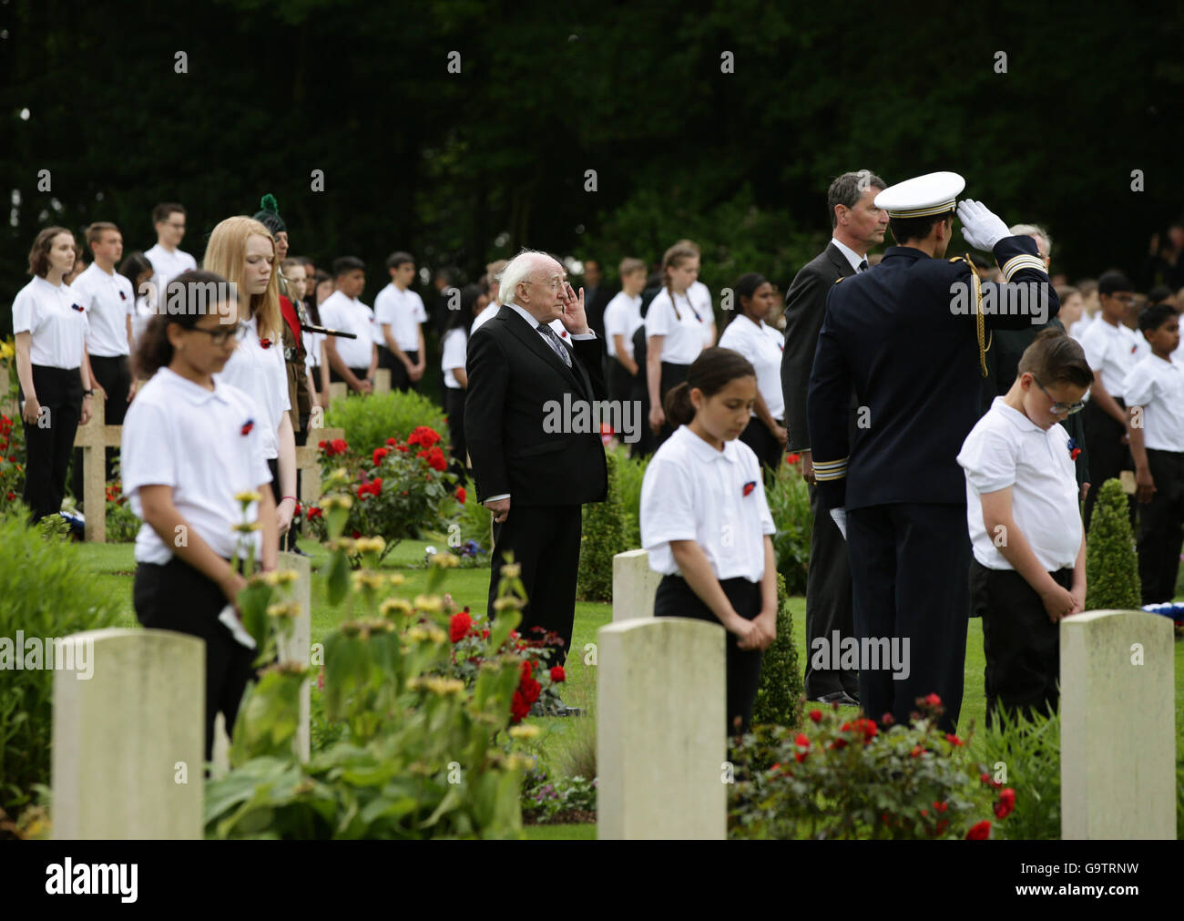 Irish President Michael D Higgins stands in respect after laying ...