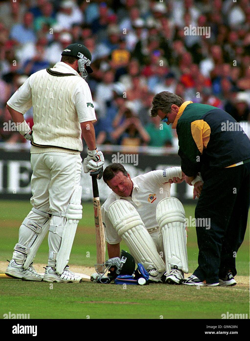 Australia's Steve Waugh grimaces in pain whilst a physio tries to aid ...