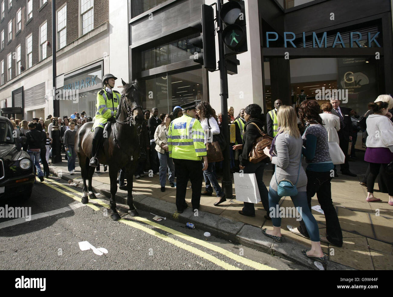 Police monitor queuing shoppers outside the new Primark flagship store ...