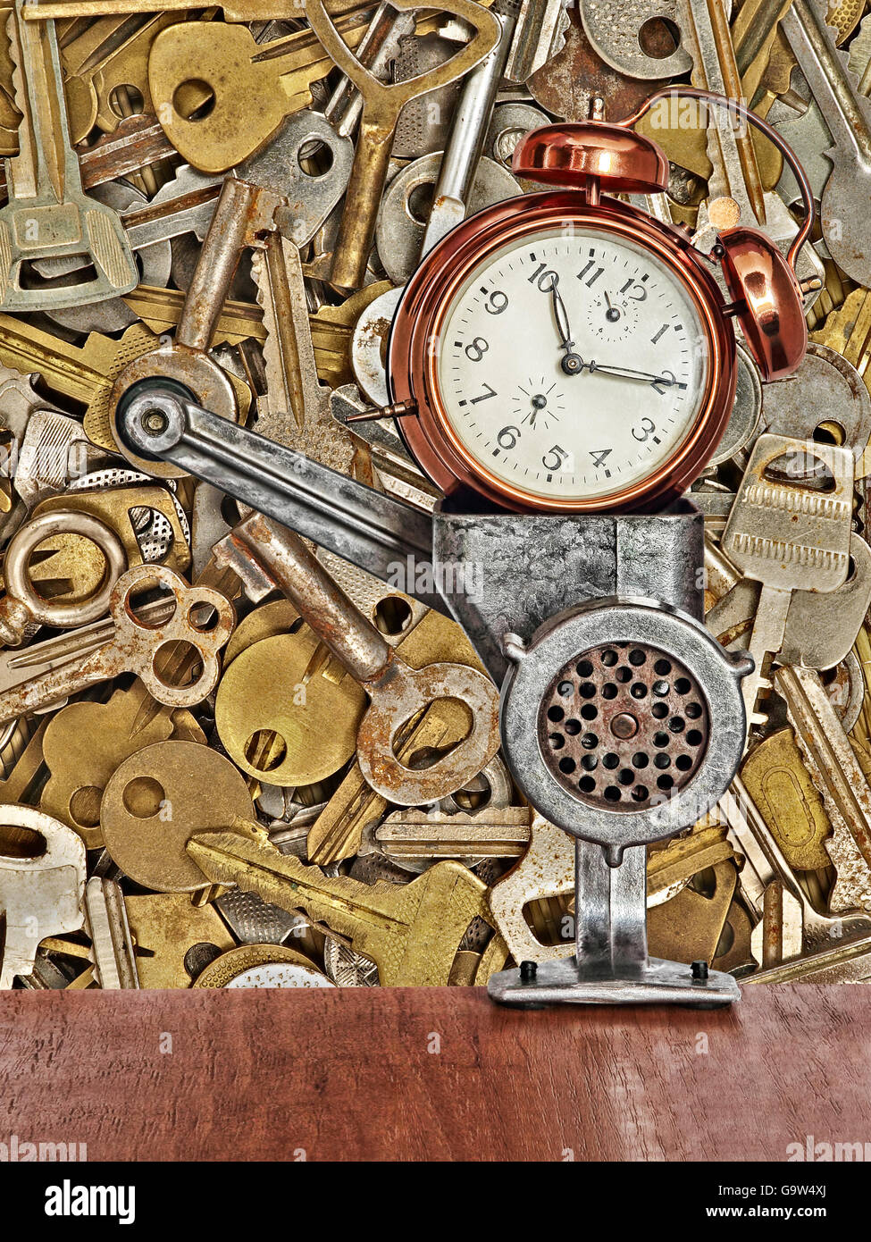 Retro alarm clock in meat grinder on old metal keys background taken ...