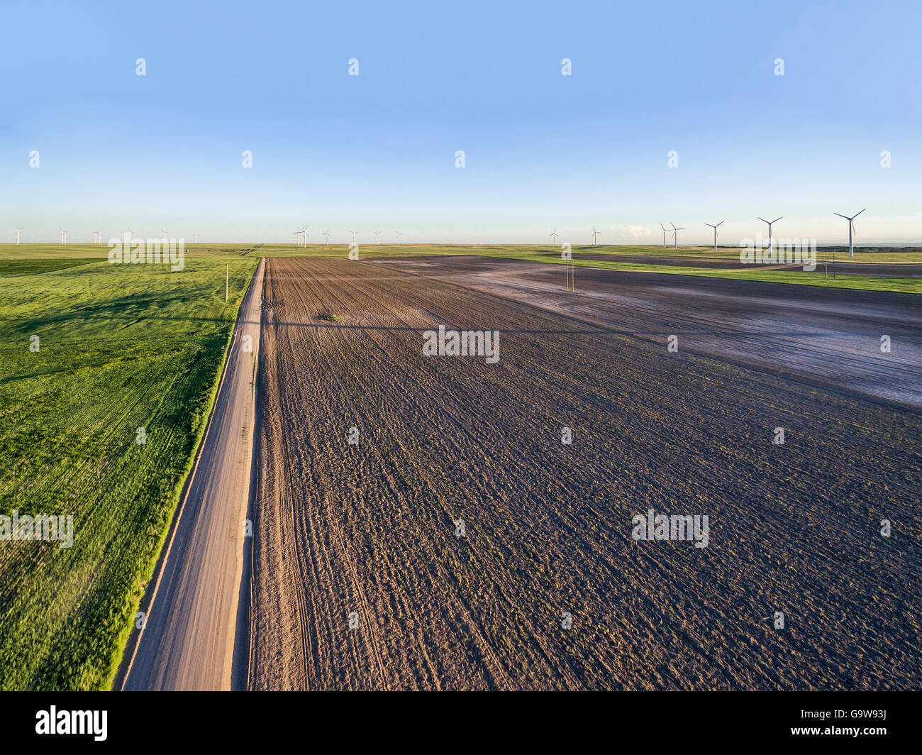 Plowed field, dirt road and windmill farm at Pawnee National Grassland ...