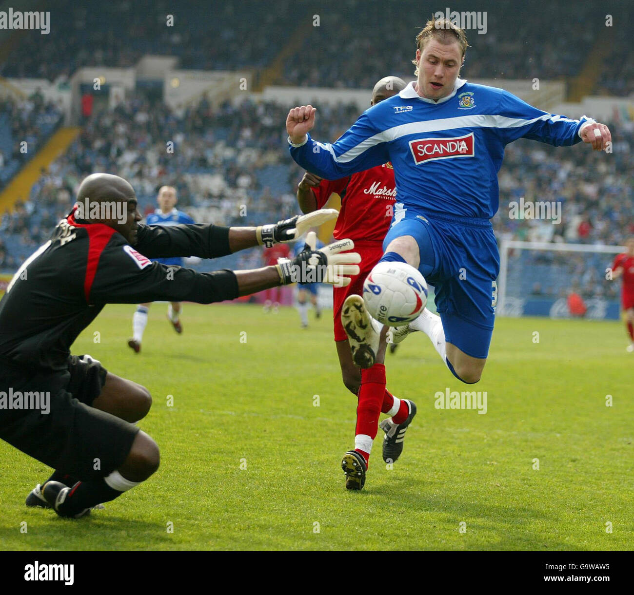 Stockport's Adam Proudlock is beaten to the ball by MK Don's goalkeeper ...