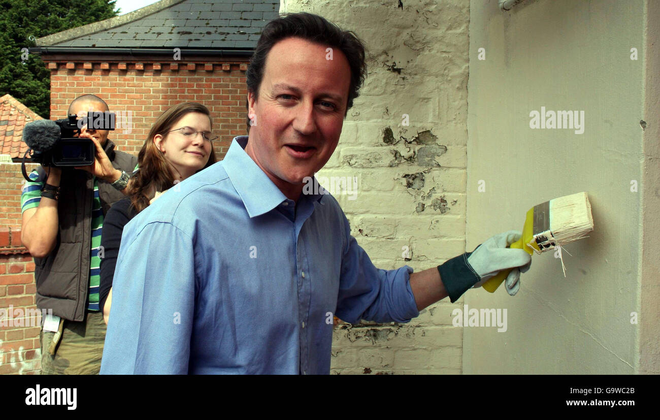 David Cameron paints over a graffiti-covered wall in Diss, Norfolk ...