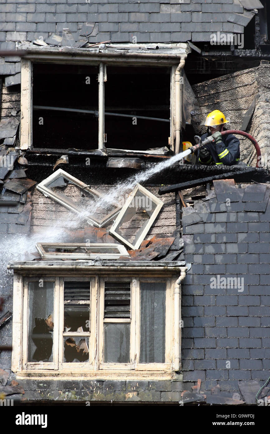 A firefighter on the roof of a building whose roof was set on fire ...
