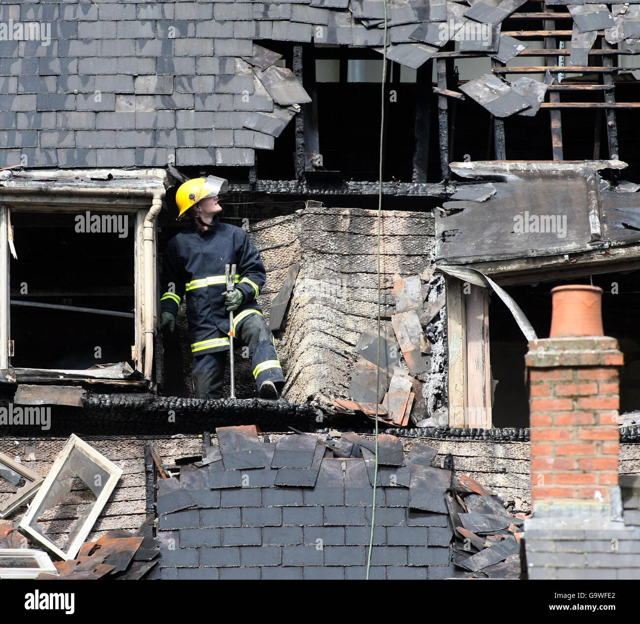 A firefighter on a building, whose roof was set on fire after an office ...
