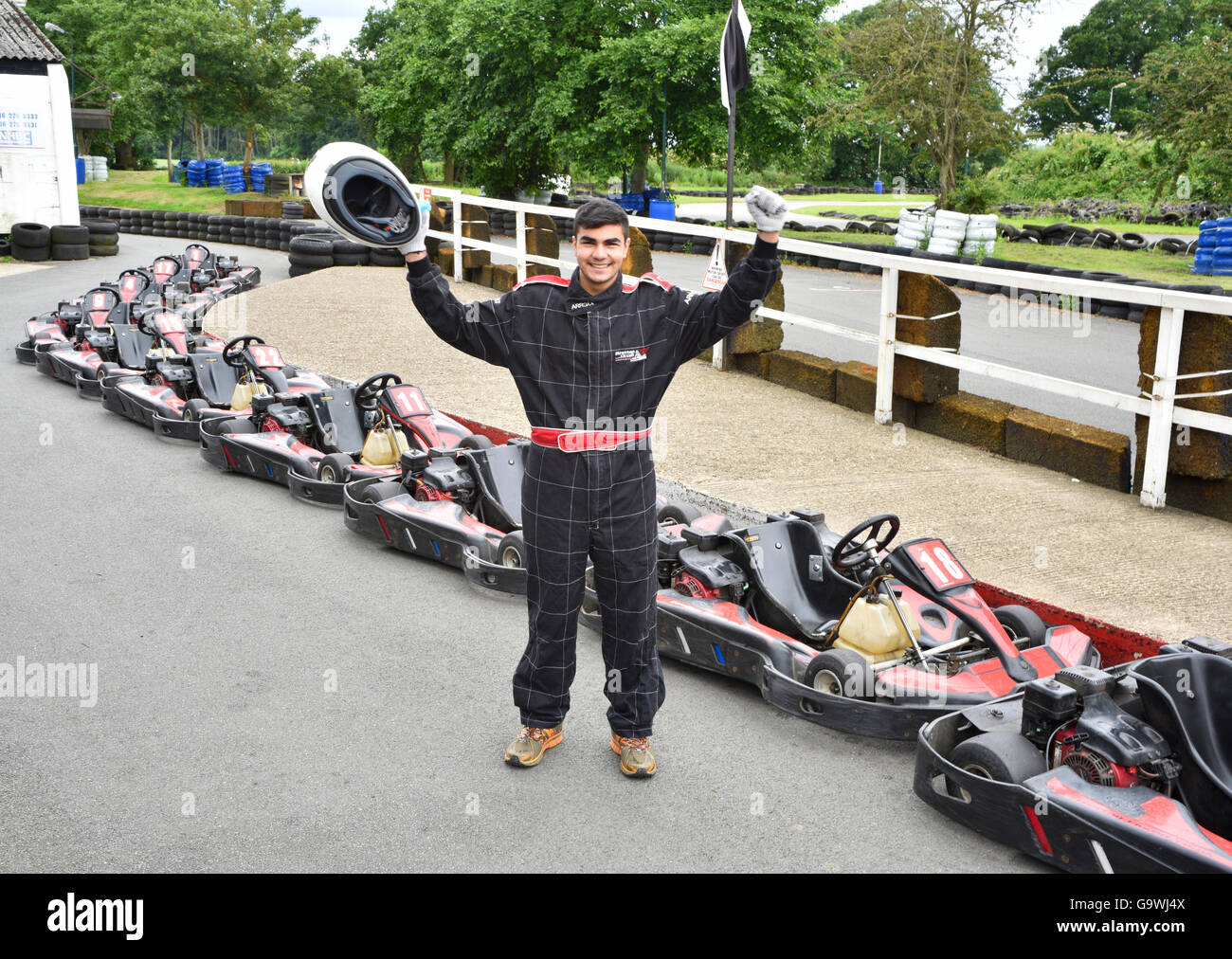 Go Cart rider in professional race-wear holding Helmet exposes winning ...