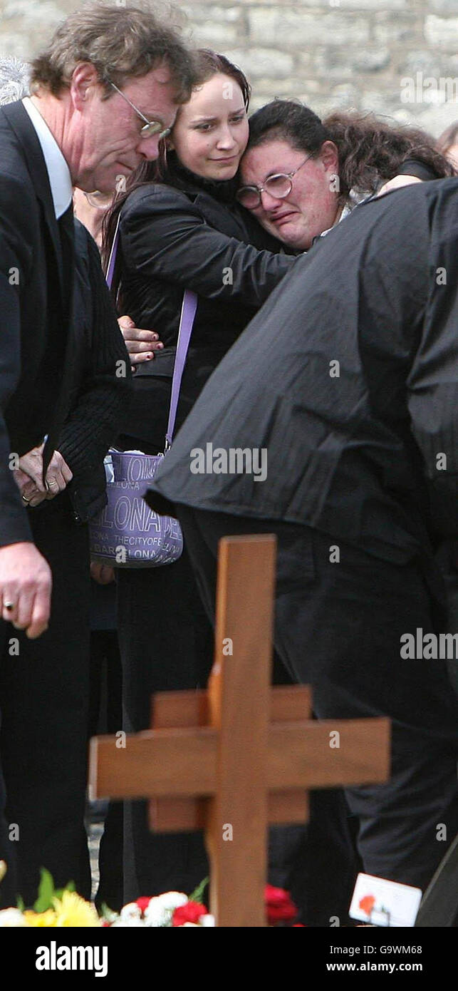 Adrian Dunne sister Maureen (right) is comforted as his coffin is laid ...
