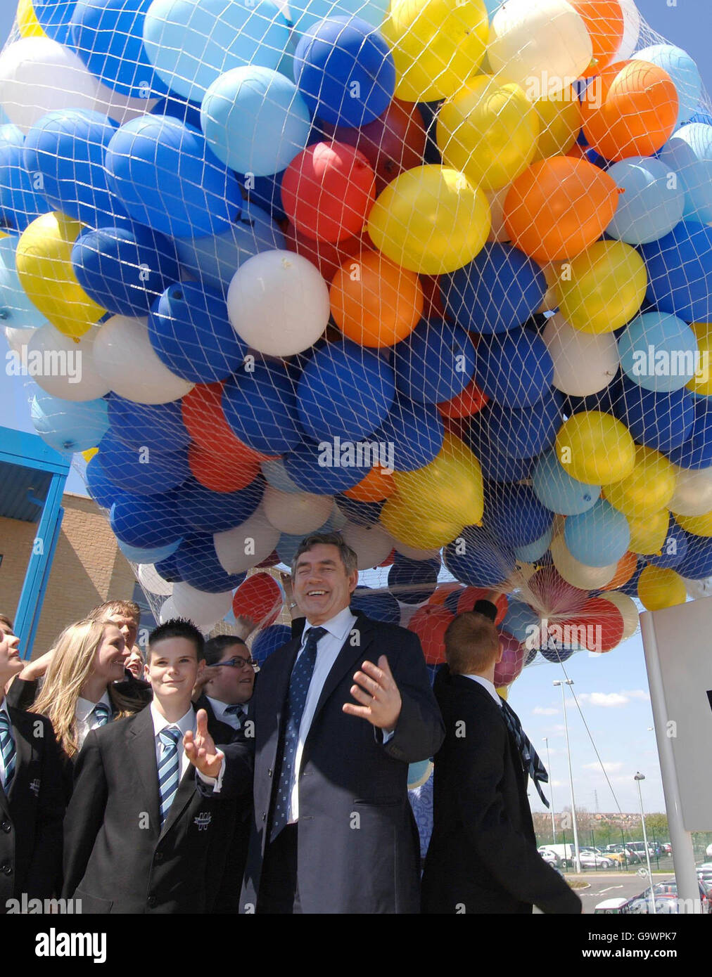 Chancellor Gordon Brown stands underneath a net full of balloons to be ...