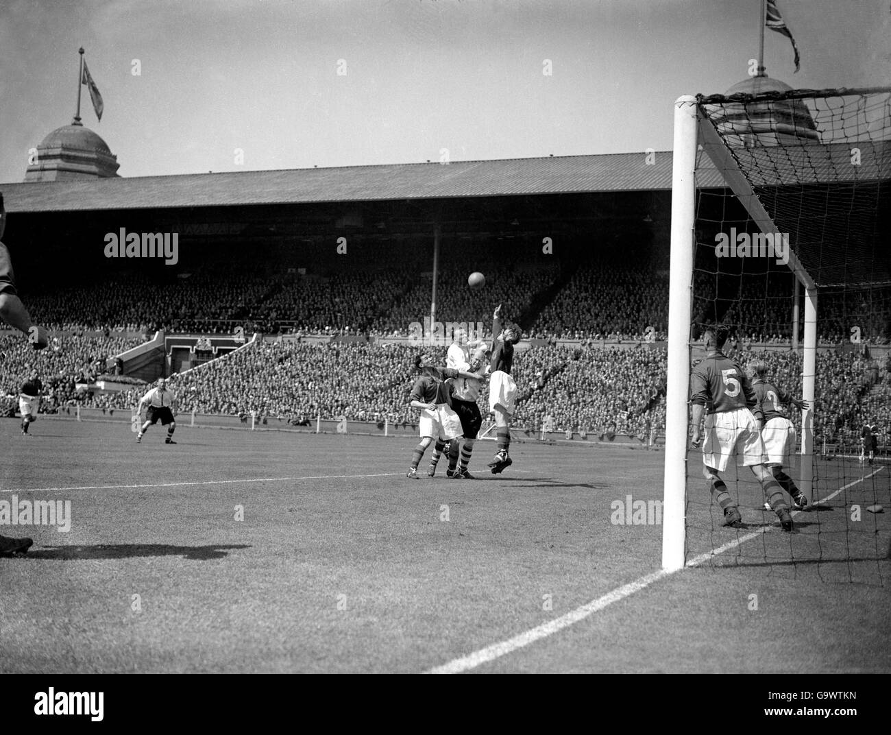 Burnley goalkeeper Jimmy Strong (third r) pushes the ball clear under ...