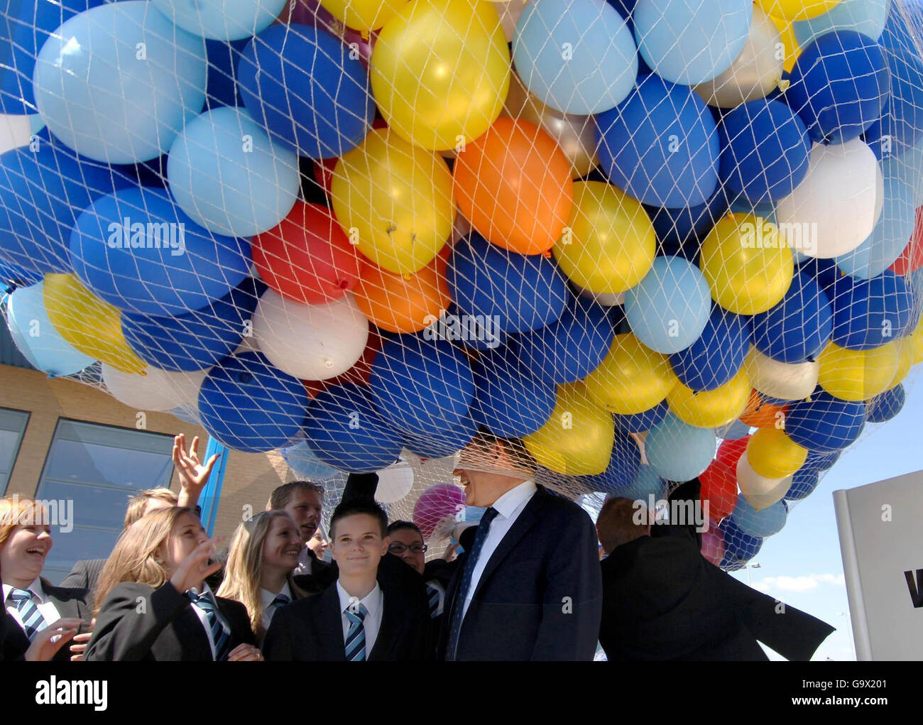 Chancellor Gordon Brown stands underneath a net full of balloons to be ...