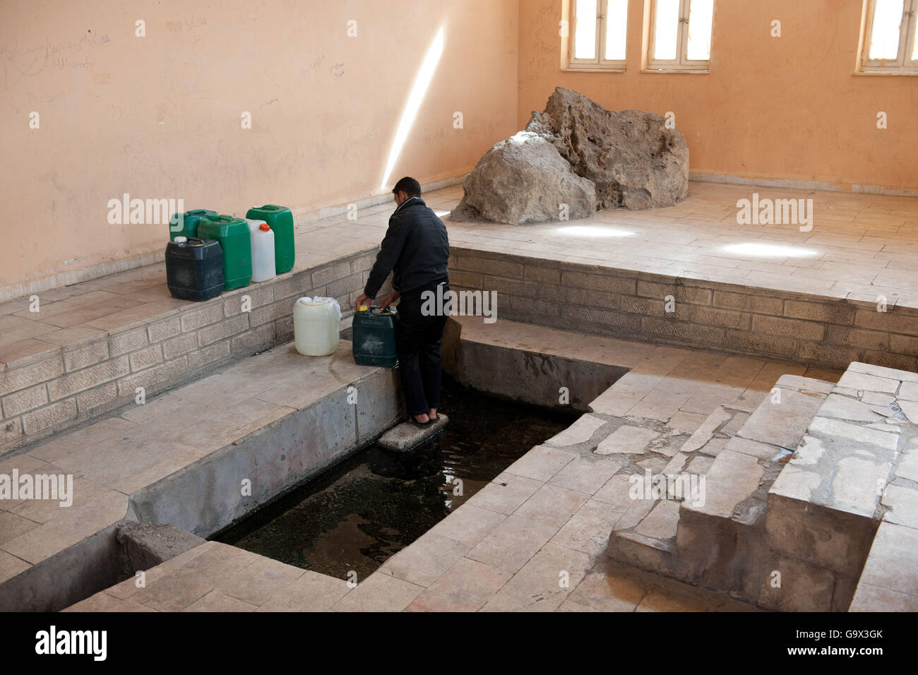 man scooping water at Moses Spring, Mussa spring, Ain Mussa, Wadi Musa ...