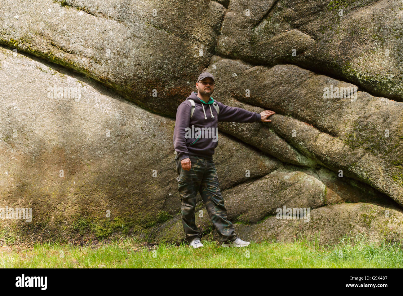 standing man leaning on a rock Stock Photo - Alamy