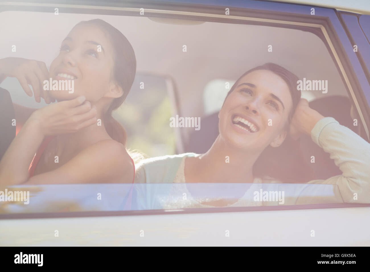 Beautiful women looking out from car window Stock Photo - Alamy