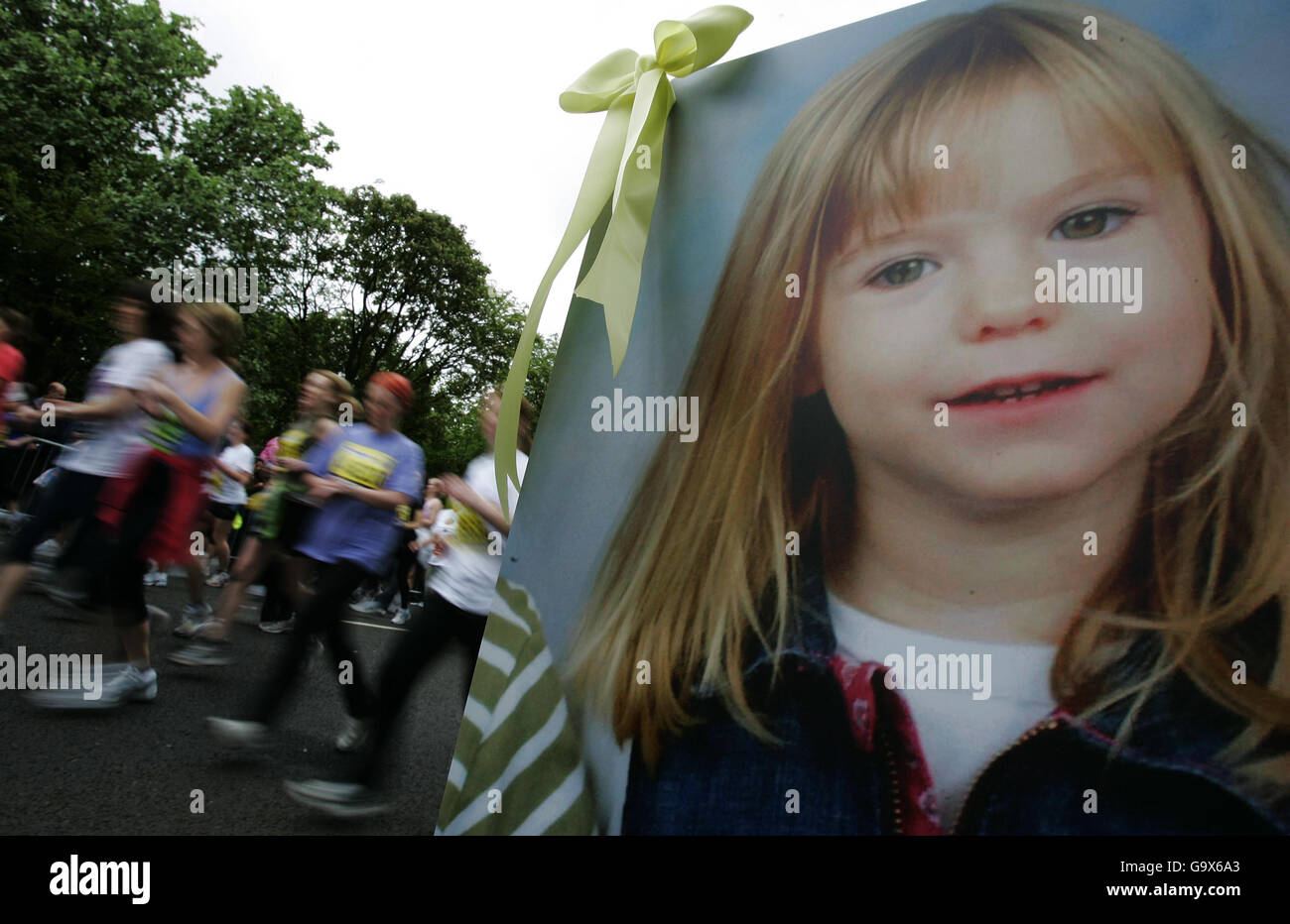 Girl missing in Algarve. Athletes run past a picture of missing child ...