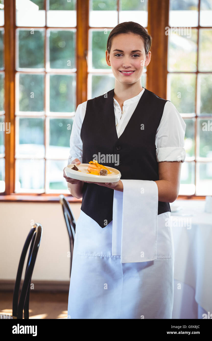 Waitress holding a plate with cakes Stock Photo - Alamy