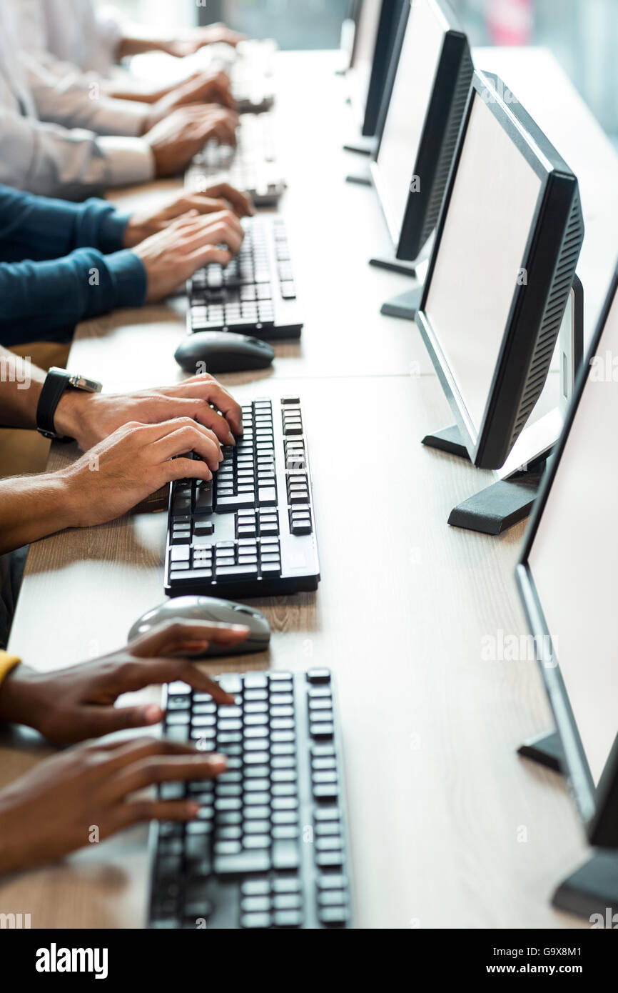Mid section of colleagues working on computer Stock Photo - Alamy